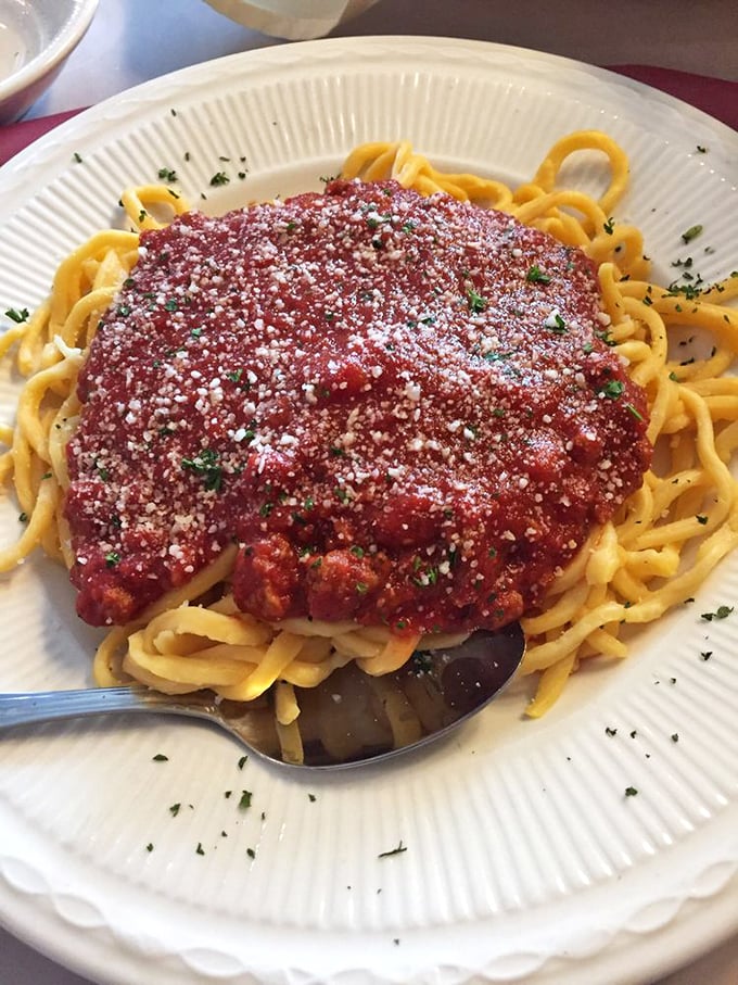 This isn't just spaghetti—it's a mountain of homemade pasta crowned with rich sauce and a snowfall of parmesan that whispers, "Take your time with me."