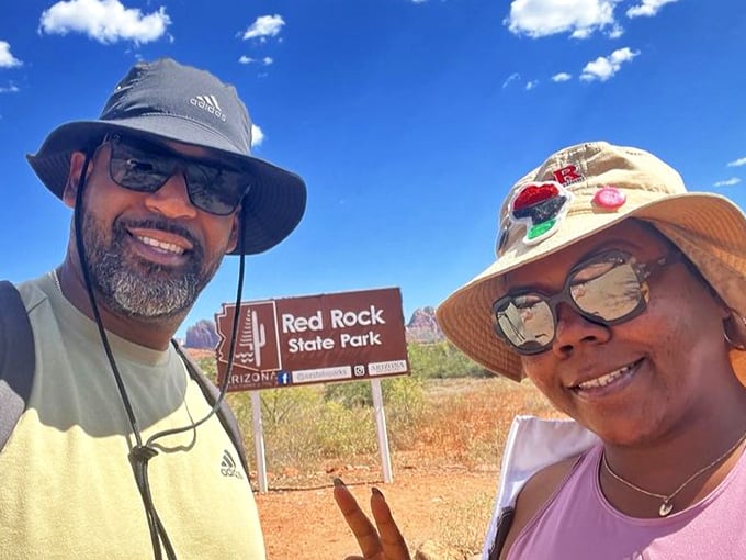 "We made it!" Visitors celebrate reaching the park entrance. That smile says, "The car AC is officially off duty—adventure mode activated!"