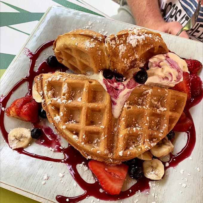 This Belgian waffle isn't just breakfast—it's art, with berries and bananas playing supporting roles to that perfect golden crunch.