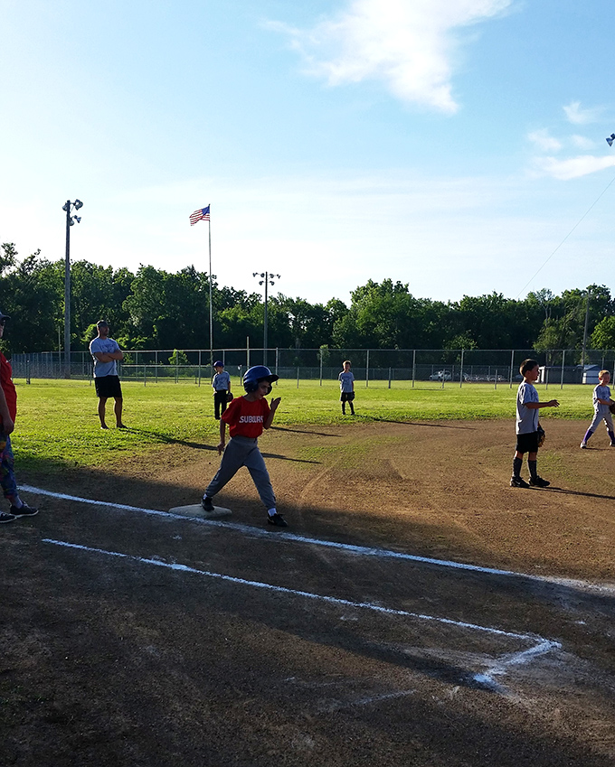 Little league dreams come alive on fields where summer evenings stretch as long as childhood memories.