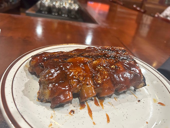 These ribs aren't just falling off the bone—they're practically jumping into your mouth, glistening with that sticky, sweet-savory sauce that requires at least three napkins.