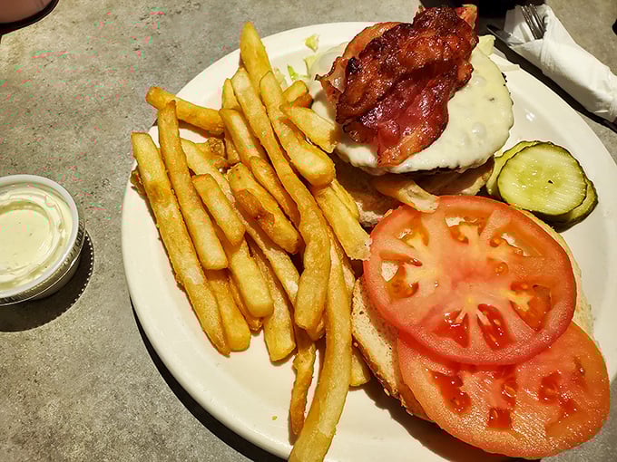 This isn't just a bacon cheeseburger—it's architecture. The golden fries, the perfectly melted cheese, the bacon standing proud like it knows what it's accomplished.