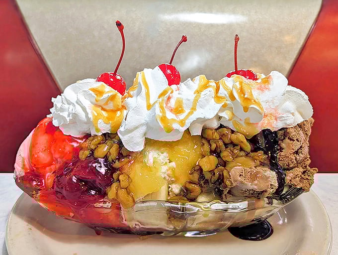The banana split arrives like a dessert fever dream – ice cream mountains topped with whipped cream clouds and cherries standing sentinel over rivers of chocolate sauce.