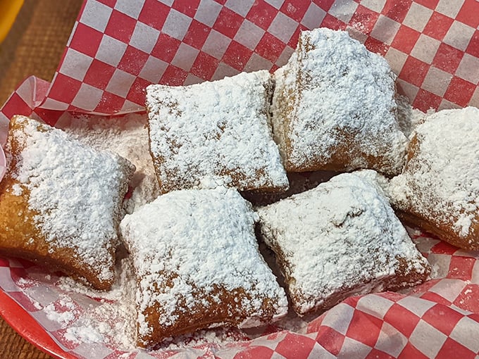 These beignets aren't just wearing powdered sugar—they're buried in a sweet avalanche that guarantees you'll leave with evidence on your shirt. Worth it.