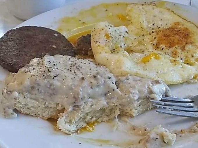 Breakfast nirvana achieved: fluffy biscuits swimming in creamy gravy alongside sunny eggs and sausage – the holy trinity of Southern morning comfort.