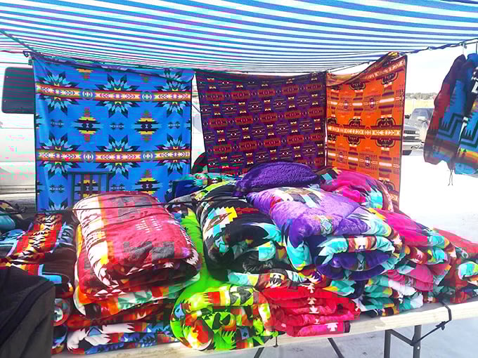 Blankets that explode with color like a New Mexican sunset, stacked in tempting piles that practically dare you not to touch them.