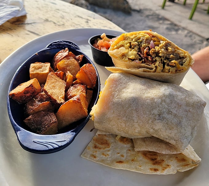 Breakfast goes coastal with this hearty burrito flanked by seasoned potatoes – the kind of morning fuel that makes you reconsider your life choices (in the best way).