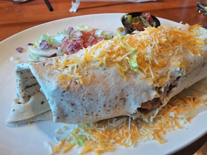Behold the breakfast burrito in its natural habitat—wrapped in a tortilla blanket, smothered in cheese, and ready to cure whatever ailed you yesterday.