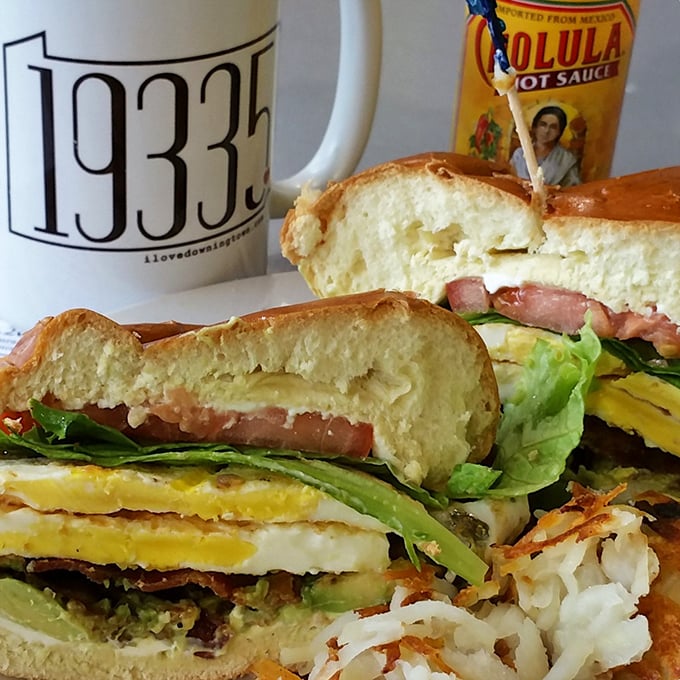 Breakfast sandwich architecture at its finest—layers of fresh ingredients stacked between pillowy bread with a side of local pride.