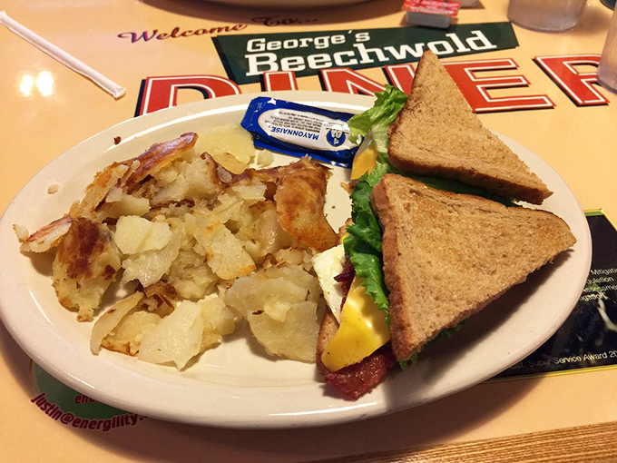 The holy trinity of breakfast: perfectly toasted bread, crispy-edged home fries, and a sandwich that doesn't need Instagram filters to look good.