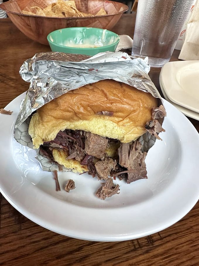 This brisket sandwich isn't just a meal, it's an event—tender, smoky meat practically falling out of its bun in delicious surrender.
