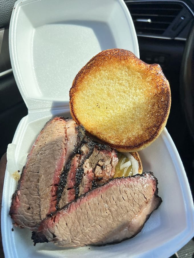 Brisket slices with that telltale pink smoke ring nestled in a takeout container – proof that sometimes the best things come in humble packages.