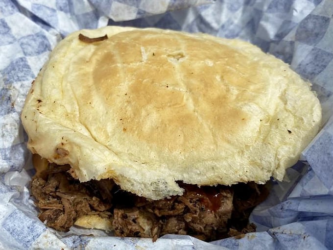 A proper brisket sandwich doesn't need fancy accessories—just pillowy bread barely containing meat that's spent hours contemplating its existence in the smoker.