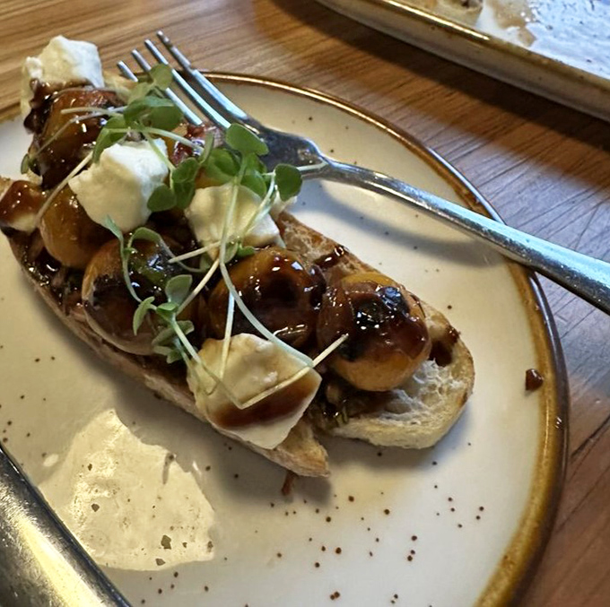 Not just bruschetta—a canvas of crusty bread topped with balsamic-kissed mushrooms, creamy cheese, and microgreens that elevate this appetizer to art form.