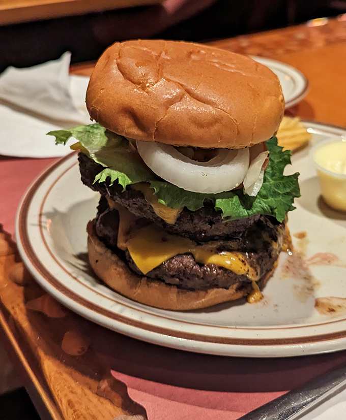 Not just a burger but a towering monument to beef architecture—where each layer contributes to a symphony of flavors that requires both hands and several napkins.