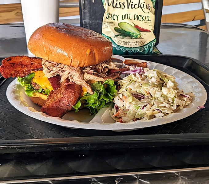 This isn't just a sandwich; it's an architectural marvel of pulled pork, bacon, and fresh veggies on a golden throne.