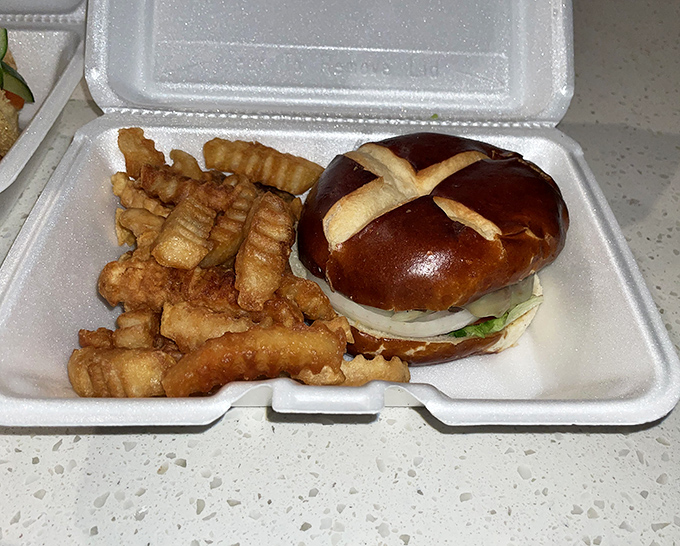 A pretzel bun burger with those signature crinkle-cut fries – proof that sometimes the best vacation souvenirs are the ones around your waistline.