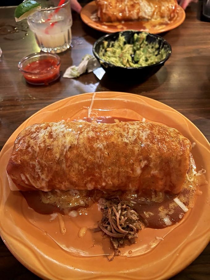Behold the burrito in its natural habitat—smothered in sauce and cheese, waiting to fulfill its destiny as tomorrow's equally delicious leftovers.