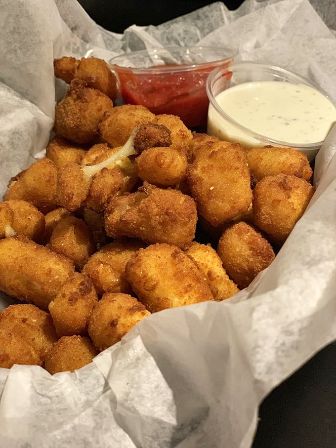 Golden-fried cheese curds that squeak between your teeth—the most delightful sound this side of the apocalypse. Dipping sauces add drama.