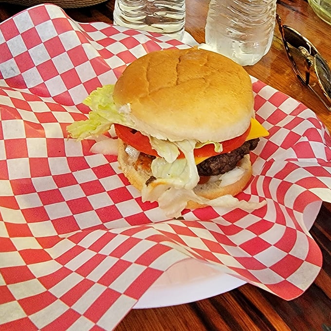This isn't just a cheeseburger; it's a hand-formed masterpiece of beef, cheese, and fresh toppings served on a classic red-checkered wrapper – no pretension, just perfection.