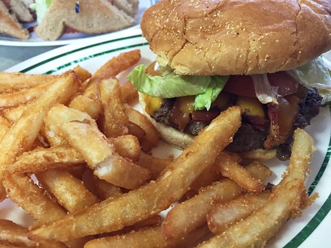 This isn't just a burger—it's architecture. Layers of beef, cheese, and fresh toppings supported by a foundation of perfectly crisp fries.