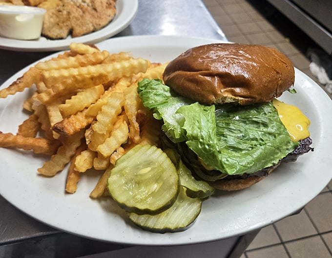 The cheeseburger that launched a thousand road trips, complete with crinkle-cut fries that make you wonder why anyone bothers with straight ones.