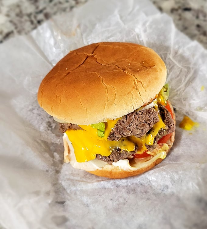 This isn't just a cheeseburger; it's edible nostalgia. The melted cheese cascades over the patty like a yellow waterfall of happiness.