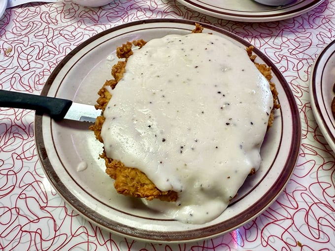 Beneath that creamy white blanket of gravy lies a chicken fried steak that's achieved the perfect crisp-to-tender ratio—comfort food engineering at its finest.