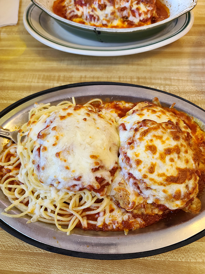 Chicken Parmesan that would make any Italian grandmother nod in approval—crispy, cheesy, and nestled on a bed of spaghetti.