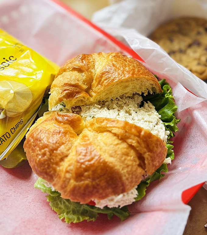 This chicken salad croissant isn't just a sandwich; it's architecture—flaky, buttery walls supporting a chicken salad interior that makes you wonder why you ever ate anything else.