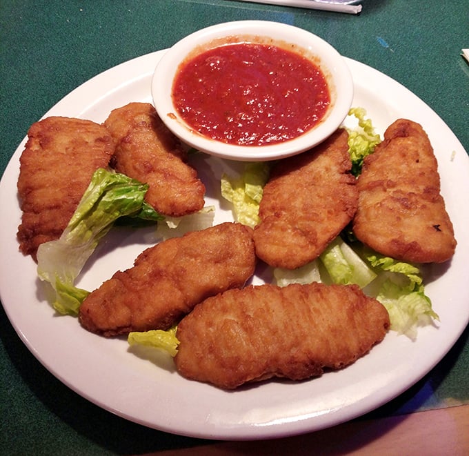 Golden-fried chicken tenders that actually deserve the word "tender" – crispy armor protecting juicy chicken within, ready for their marinara bath.