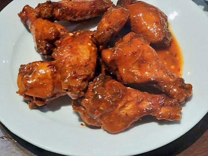 Buffalo wings that don't mess around. That glossy sauce promises the perfect balance of heat and tang—napkins required, regrets impossible.