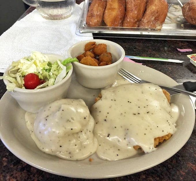 Chicken fried steak swimming in pepper-flecked gravy—a Texas baptism of sorts. Those golden okra nuggets aren't just a side dish; they're little crunchy treasures.