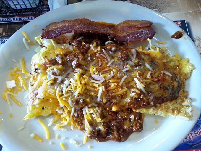 Hash browns loaded with cheese and chili alongside bacon—because subtle was never really Texas's thing, and we're grateful for it.