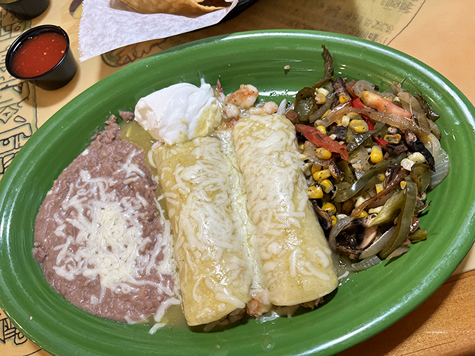 Green enchiladas nestled beside perfectly executed rice and beans—proof that even in a seafood joint, the Mexican classics get the respect they deserve.