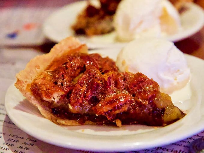 Pecan pie that doesn't mess around—rich, gooey, and served with ice cream melting alongside like it's auditioning for a dessert calendar.
