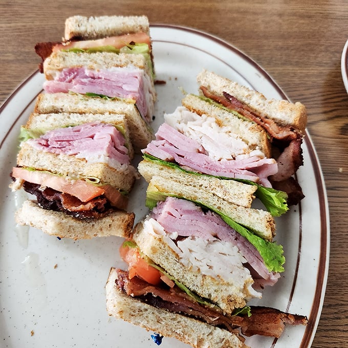 This club sandwich isn't playing around—stacked higher than Utah's mountains with layers of meat that would make a deli owner blush.