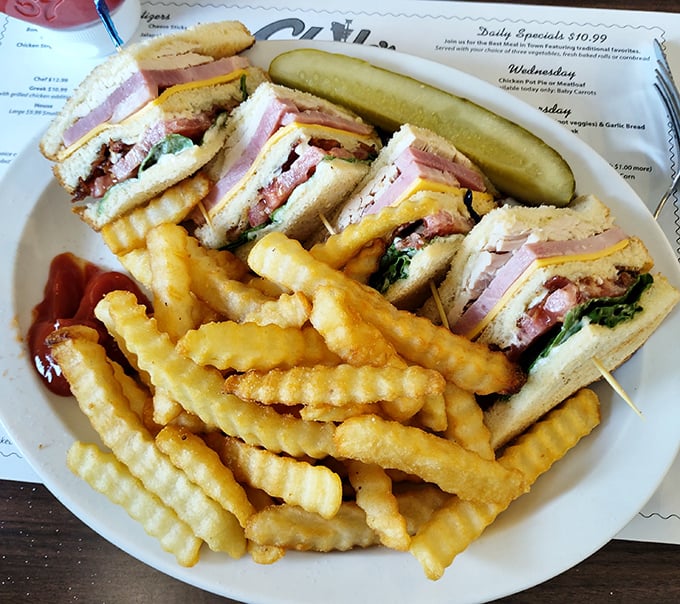 This club sandwich isn't just stacked with layers – it's stacked with flavor, accompanied by crinkle-cut fries that would make any potato proud.