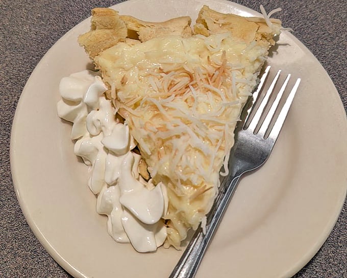 Coconut cream pie that would make your grandmother both proud and jealous. The whipped cream isn't just a topping—it's the cloud this slice floated in on.