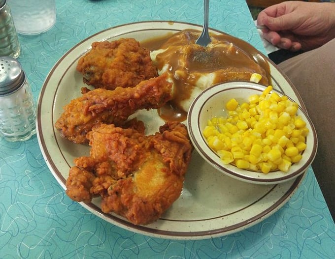 Comfort food masterpiece alert! Golden fried chicken alongside mashed potatoes drowning in gravy – your diet's worst nightmare and your soul's best friend.