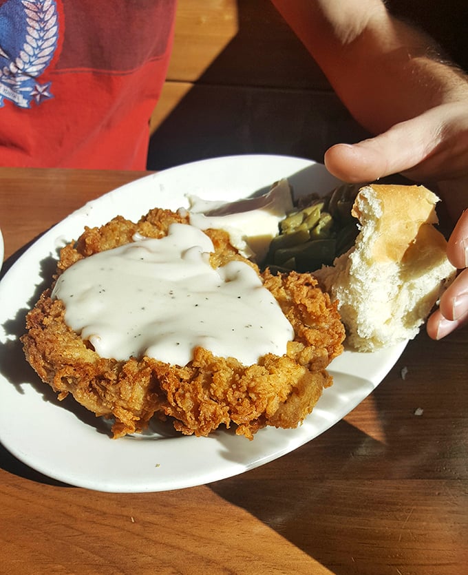 Country fried steak smothered in gravy that could make a vegetarian weep with temptation. That biscuit isn't just a side—it's an essential gravy delivery system.