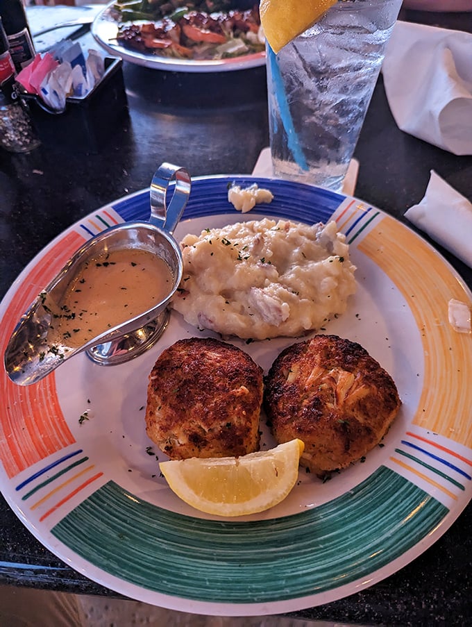 These crab cakes aren't just browned—they're bronzed, like Florida retirees who've found their perfect beach spot. The sauce boat is a welcome companion.