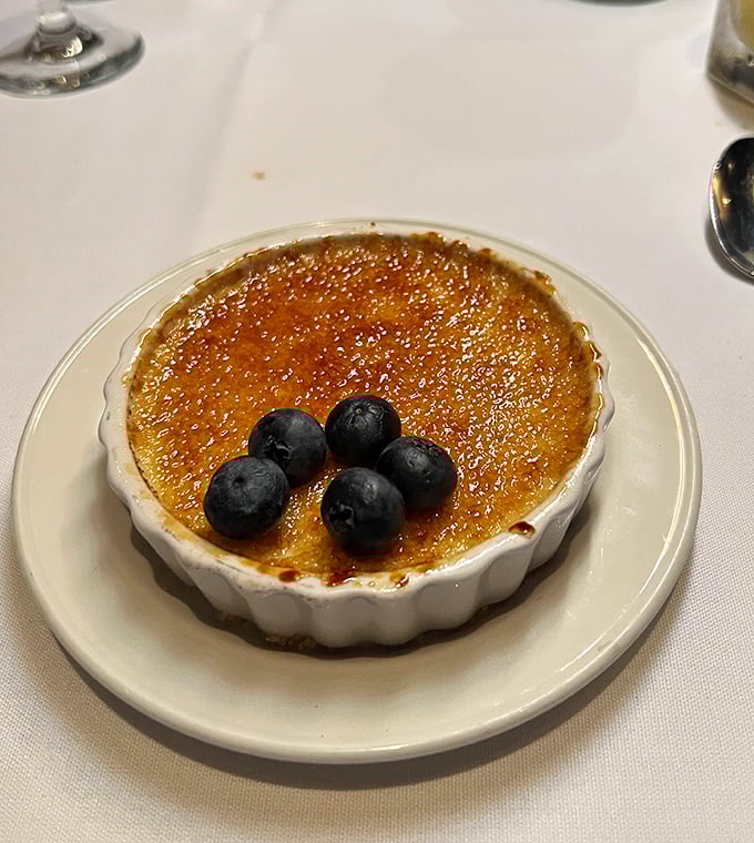The crème brûlée's crackling sugar top gives way to silky custard beneath—like breaking through ice on a pristine winter pond.