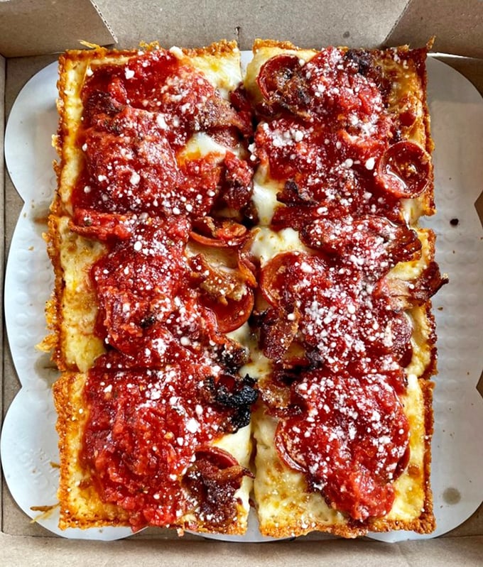 Detroit-style pizza in all its glory – those crispy, caramelized cheese edges are the culinary equivalent of finding an extra $20 in your pocket.