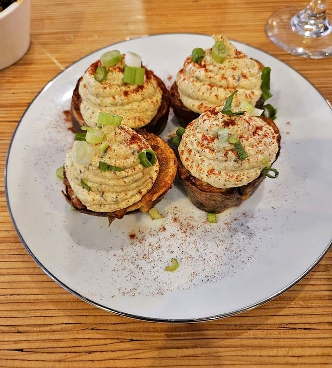 These deviled potato skins with their perfect piping and paprika dusting aren't just appetizers – they're edible art that happens to taste incredible.