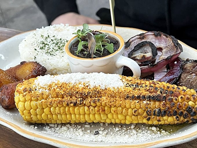 Rice, beans, grilled corn, and perfectly cooked meat—this plate understands that simple done right beats complicated done wrong.