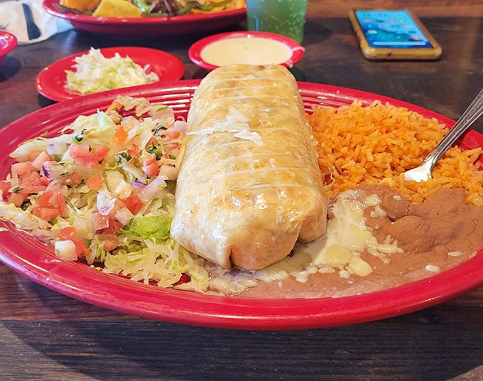 The chimichanga arrives like royalty on its throne of Spanish rice, the perfect balance of crispy exterior and tender, flavorful filling.