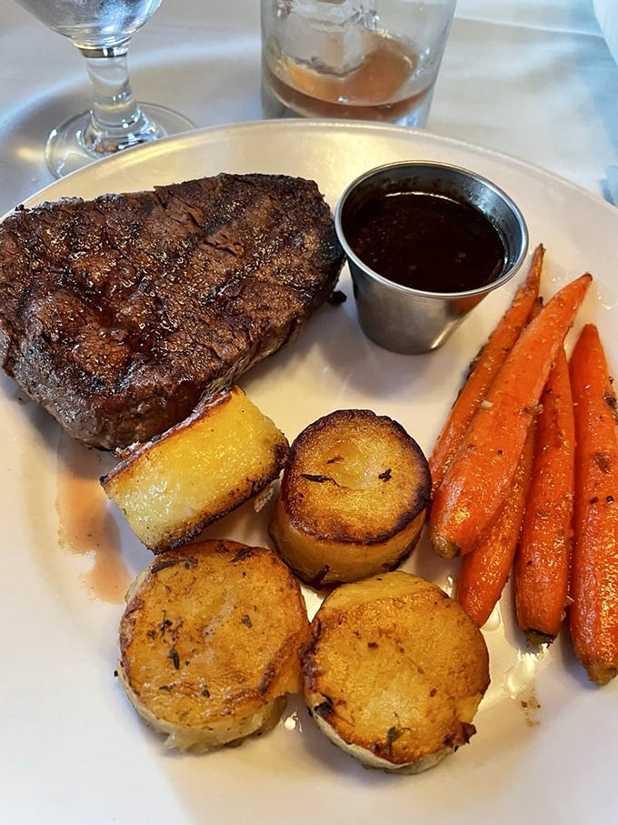 A perfectly seared filet mignon shares the spotlight with roasted potatoes and carrots – proof that simplicity, when done right, is culinary genius.