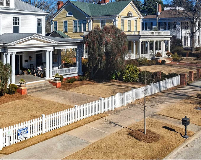 These historic homes with their pristine white picket fences aren't movie props—they're real residences where Covington families actually live their Norman Rockwell lives.