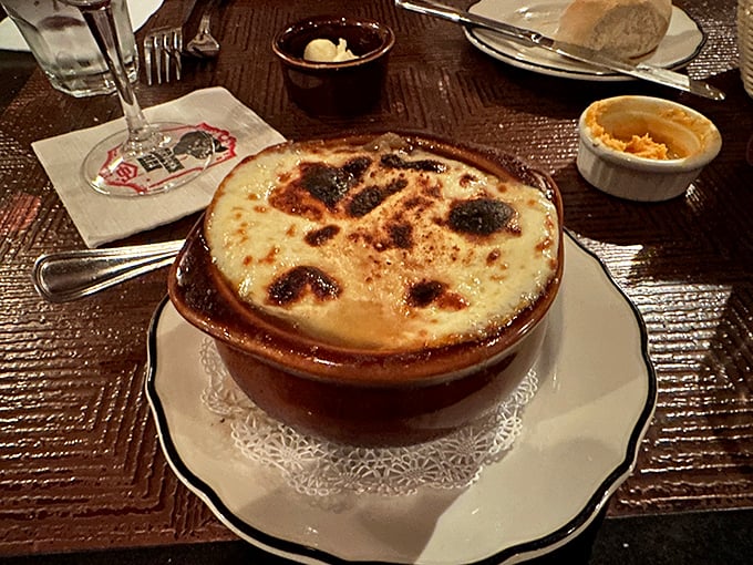 This isn't just French onion soup; it's a cheese-crowned masterpiece with a bubbling, bronzed top that demands to be cracked like crème brûlée.